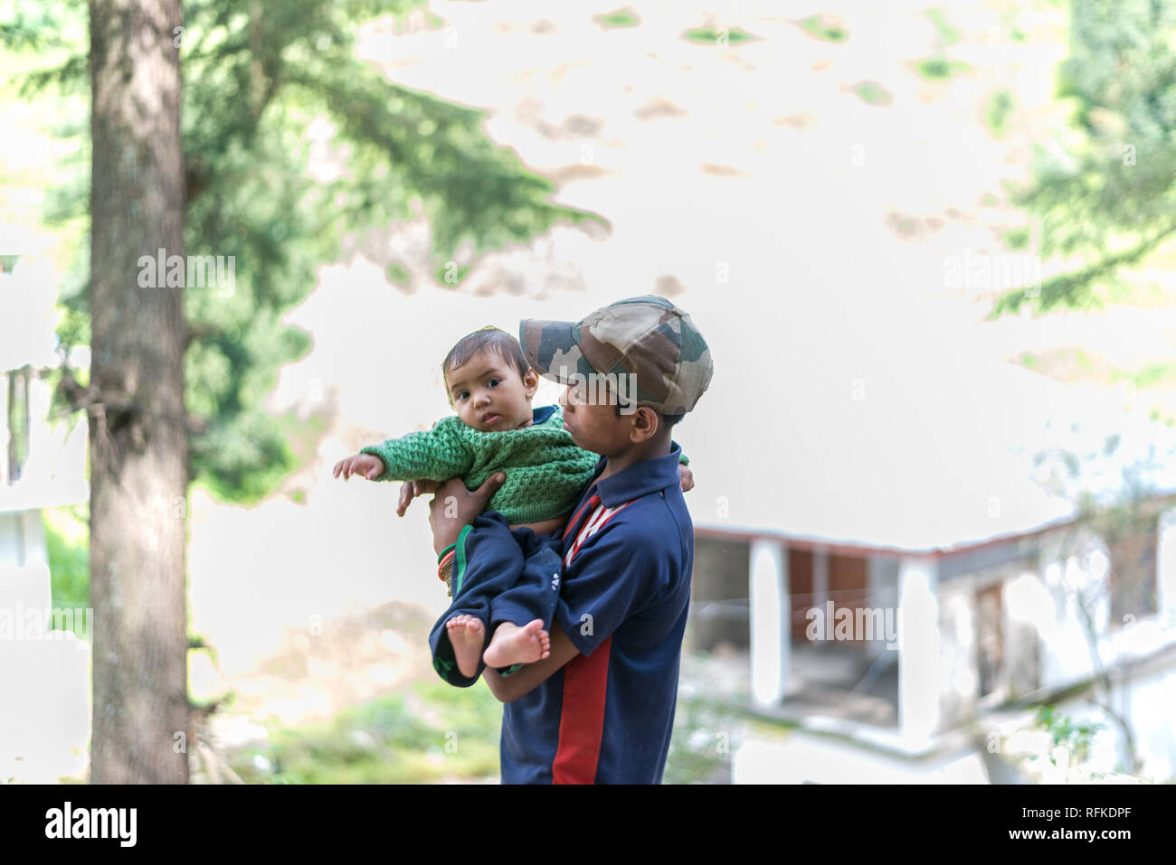 Photo of Boy with baby in himalayas, Great Himalayan National Park ...