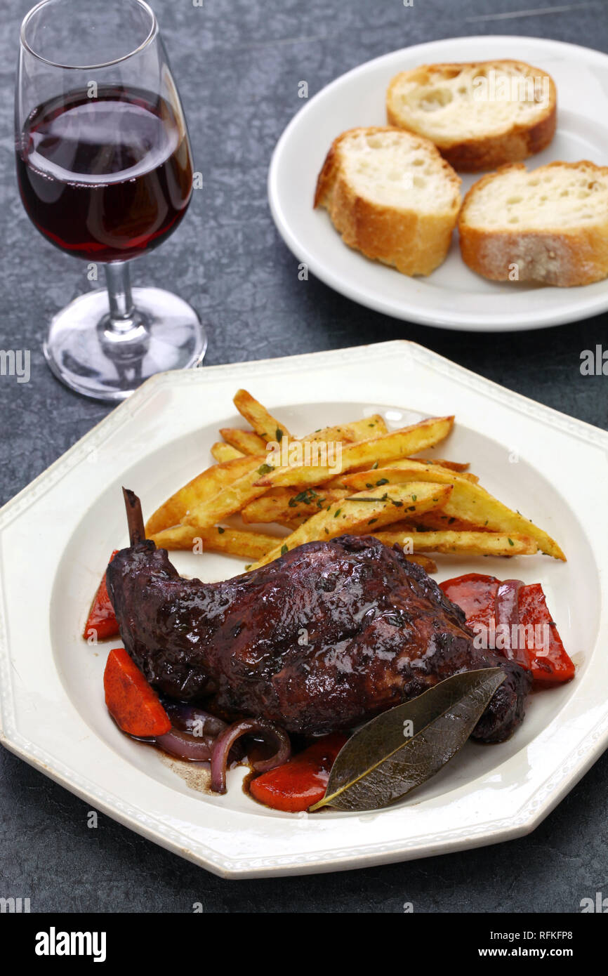 rabbit cooked in red wine with french fries Stock Photo - Alamy