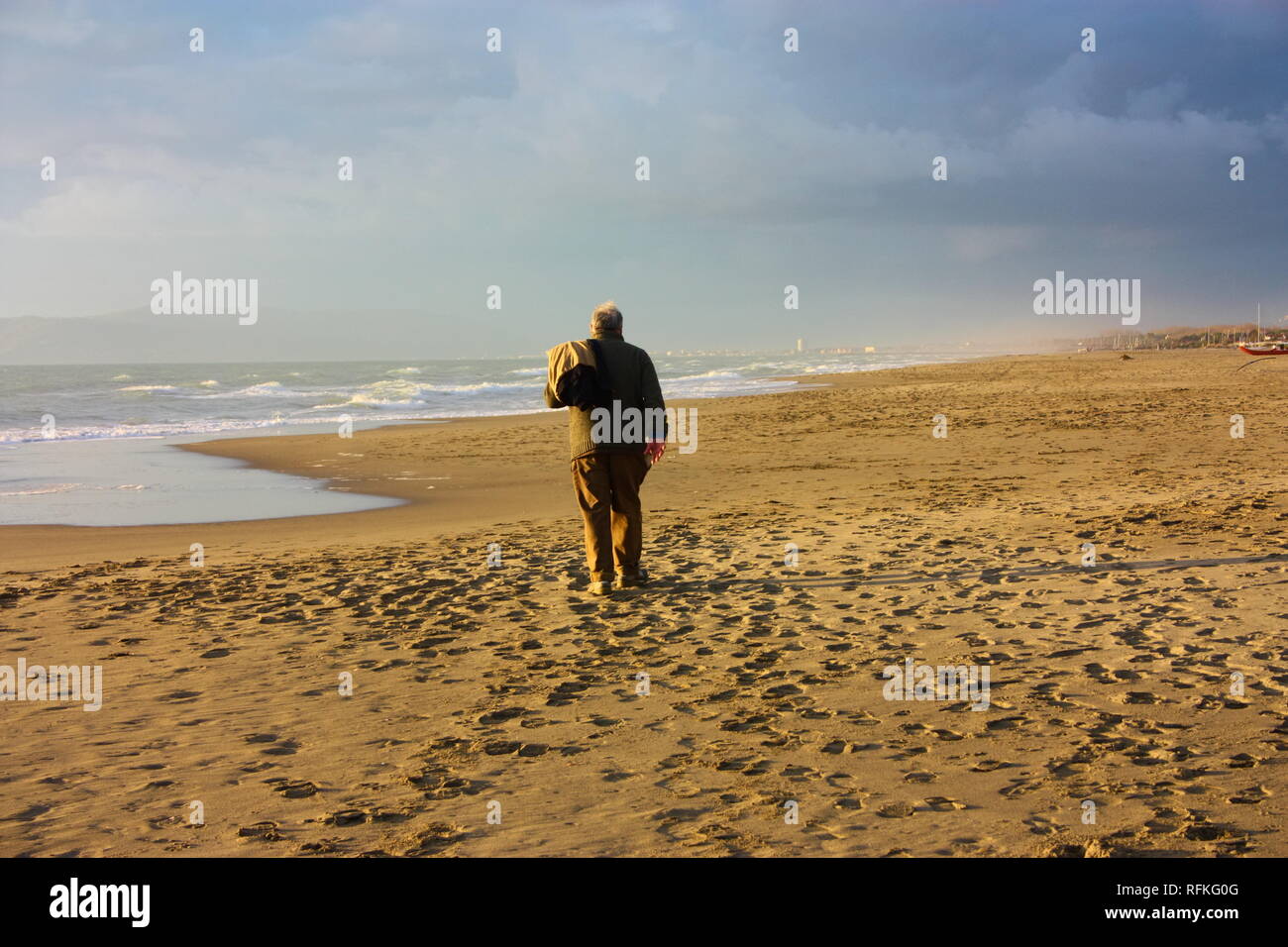 the loneliness of a man walking alone on a desolate winter beach Stock ...