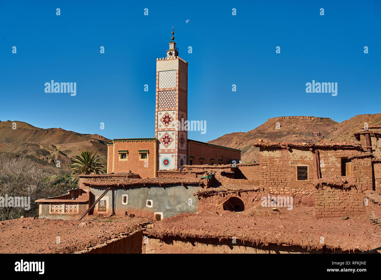 Traditional mud brick village houses and colorfully decorated minaret ...