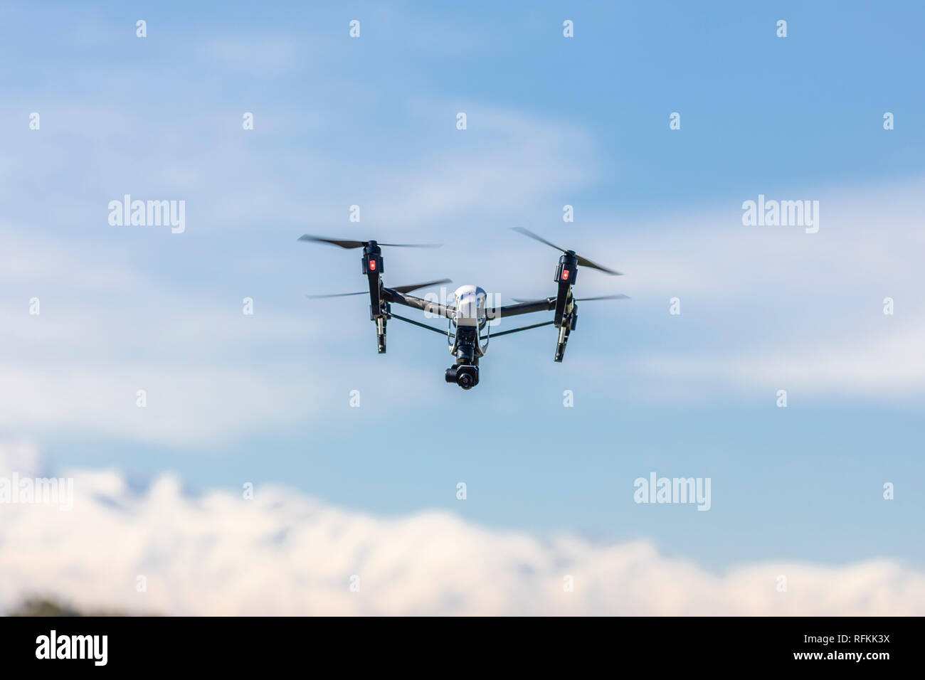 Unmanned Aerial Vehicle (UAV) or drone flying silhouetted above the ...