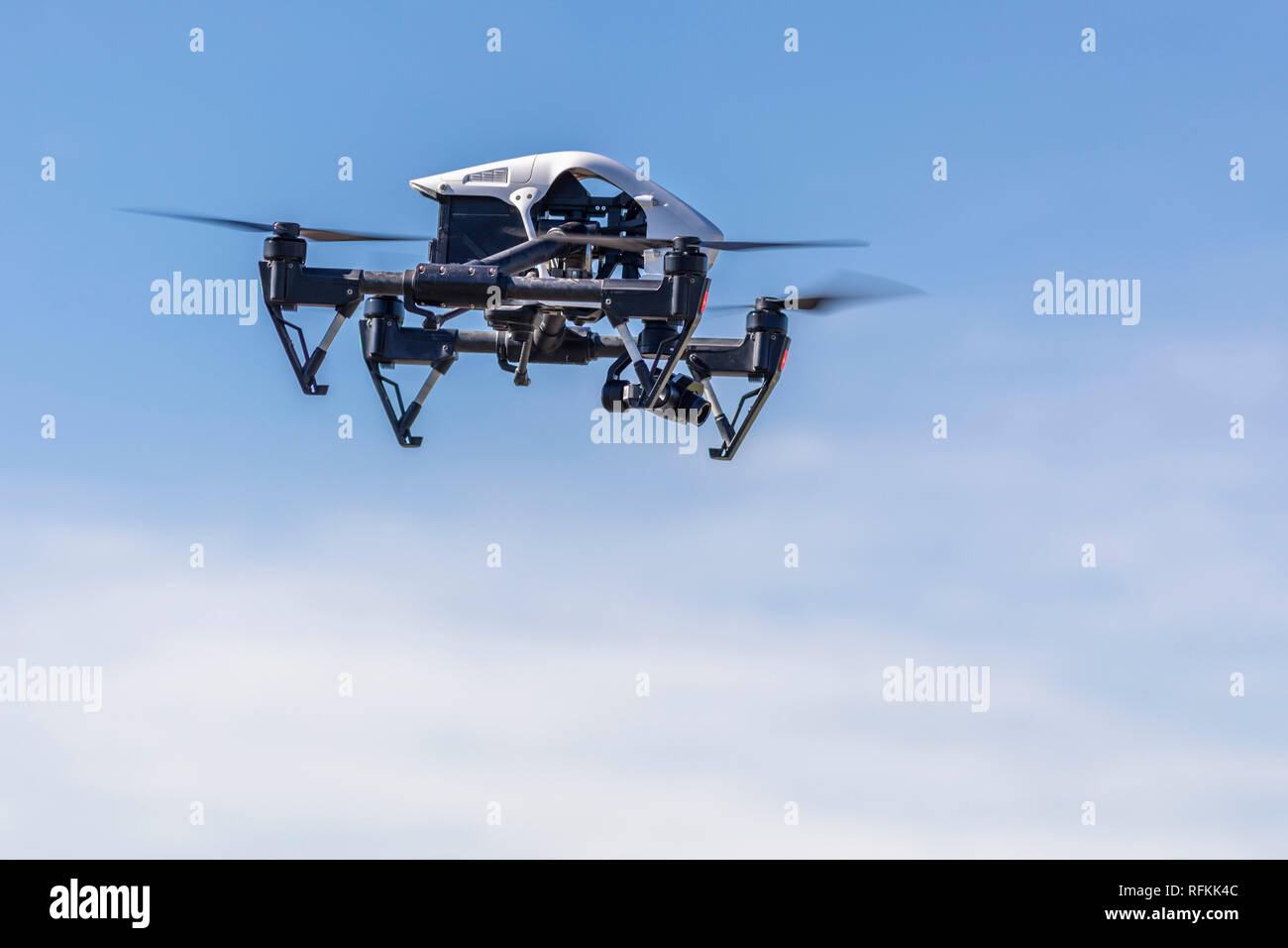 Unmanned Aerial Vehicle (UAV) or drone flying silhouetted above the ...