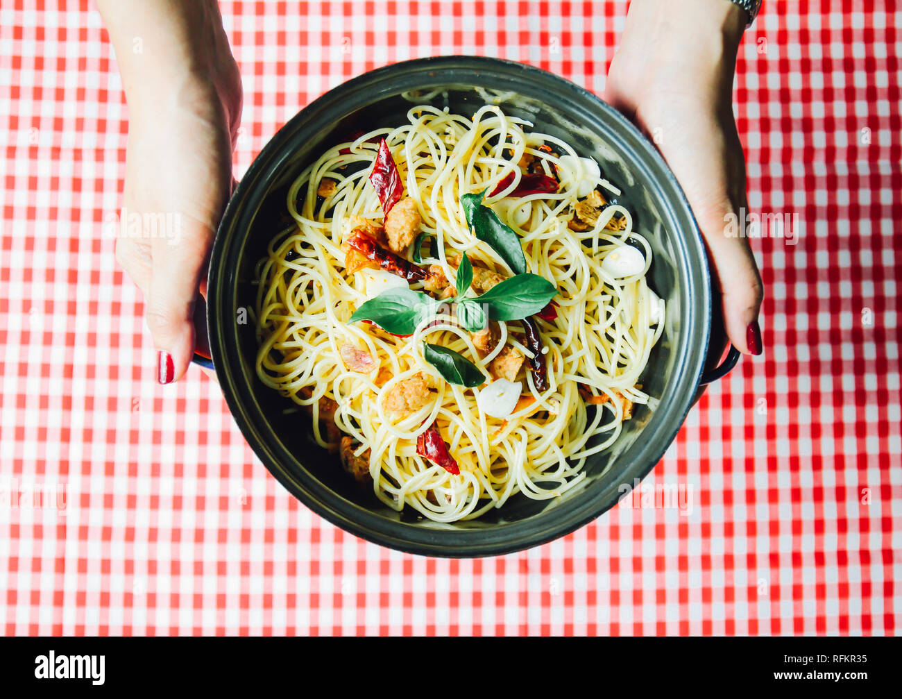 Hand holding homemade spaghetti on tablecloth Stock Photo - Alamy