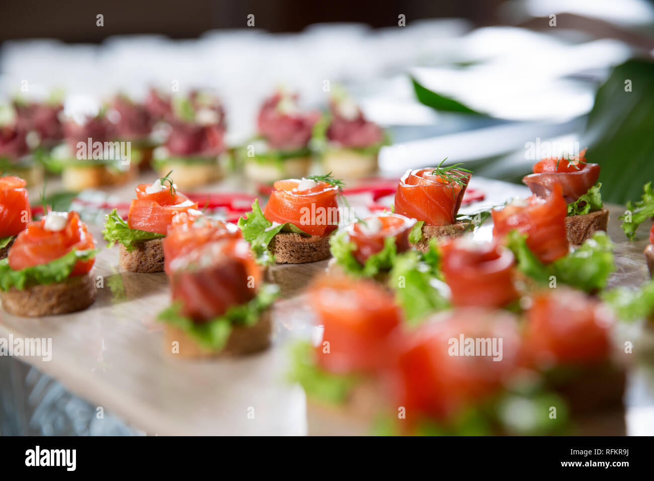 Mini canapes with smoked salmon decorated with lettuce and dill on ...