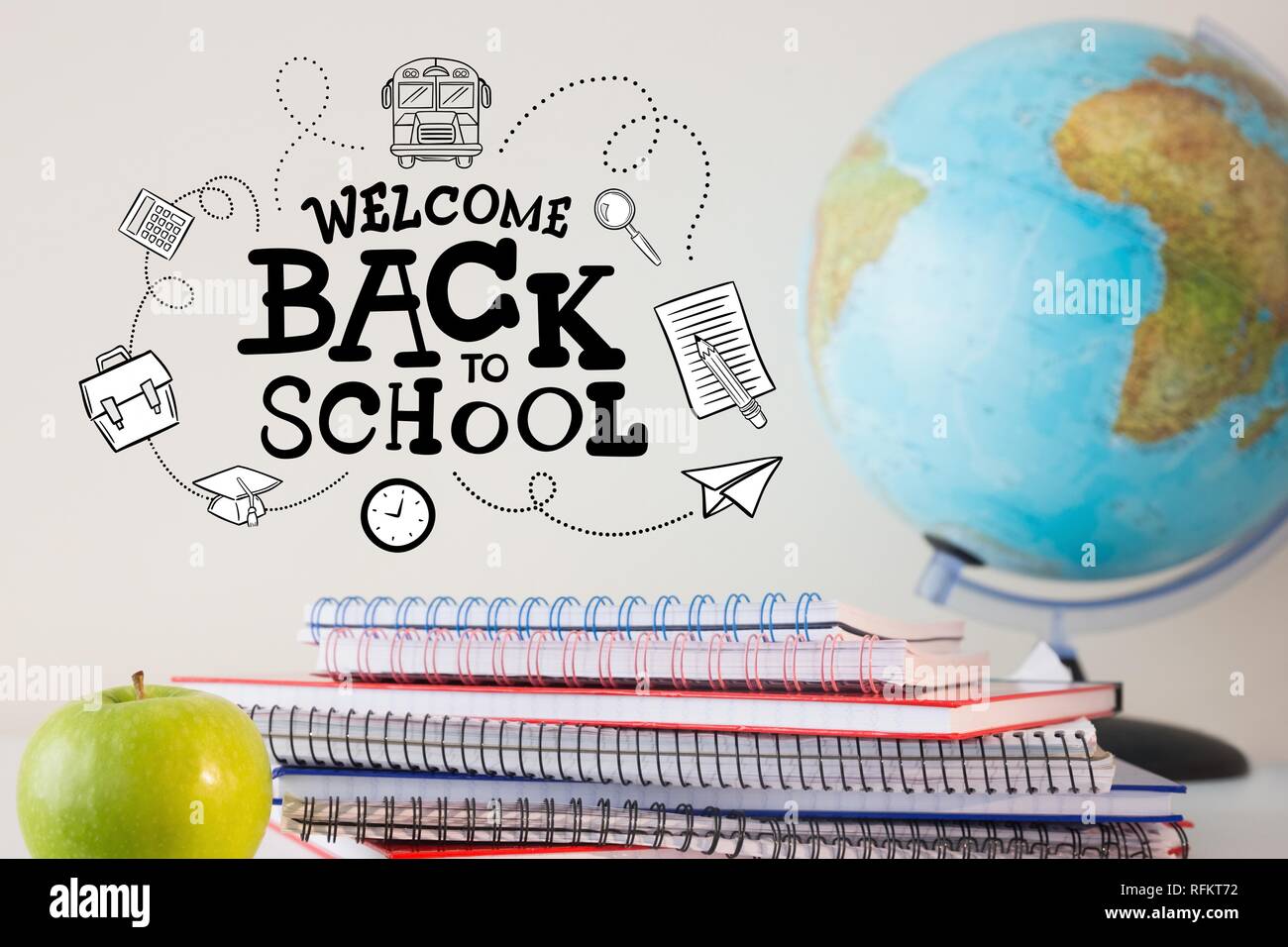 Composite of welcome back to school text with notebooks globe and apple ...