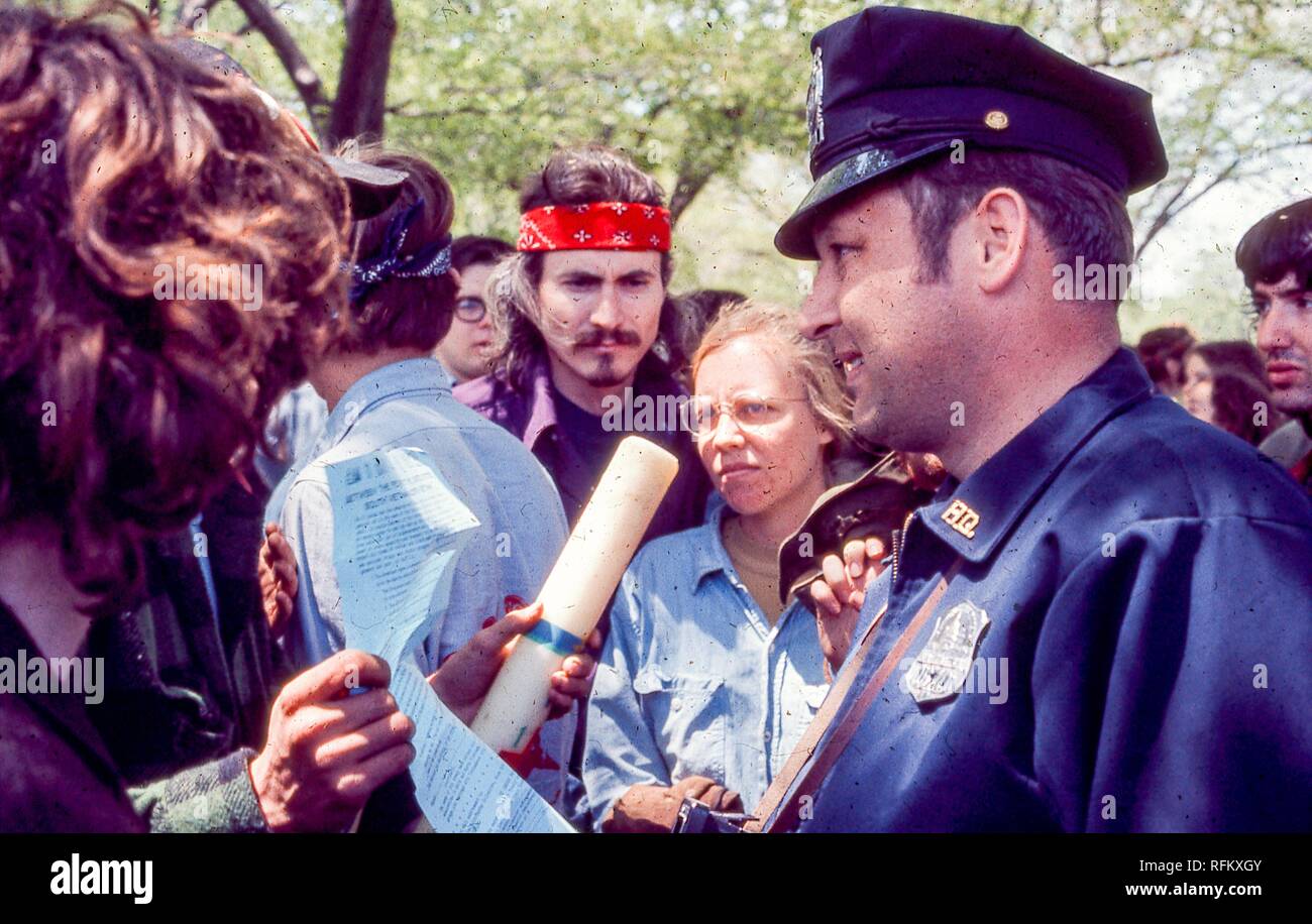 Protesters in hippie attire show paperwork to a policeman during the ...