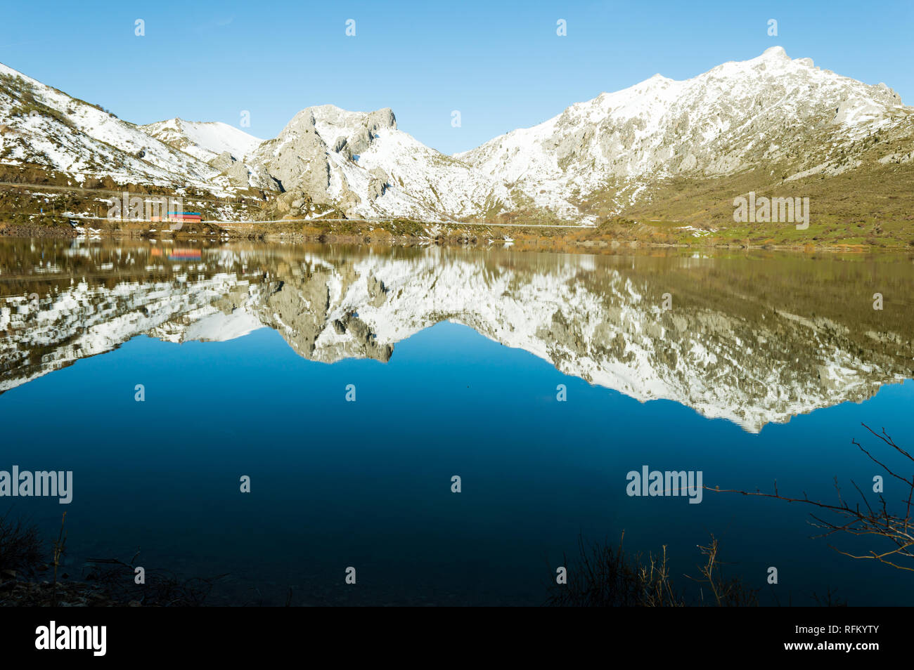 The hills covered with snow are reflected in a lake of Barrios De Luna ...