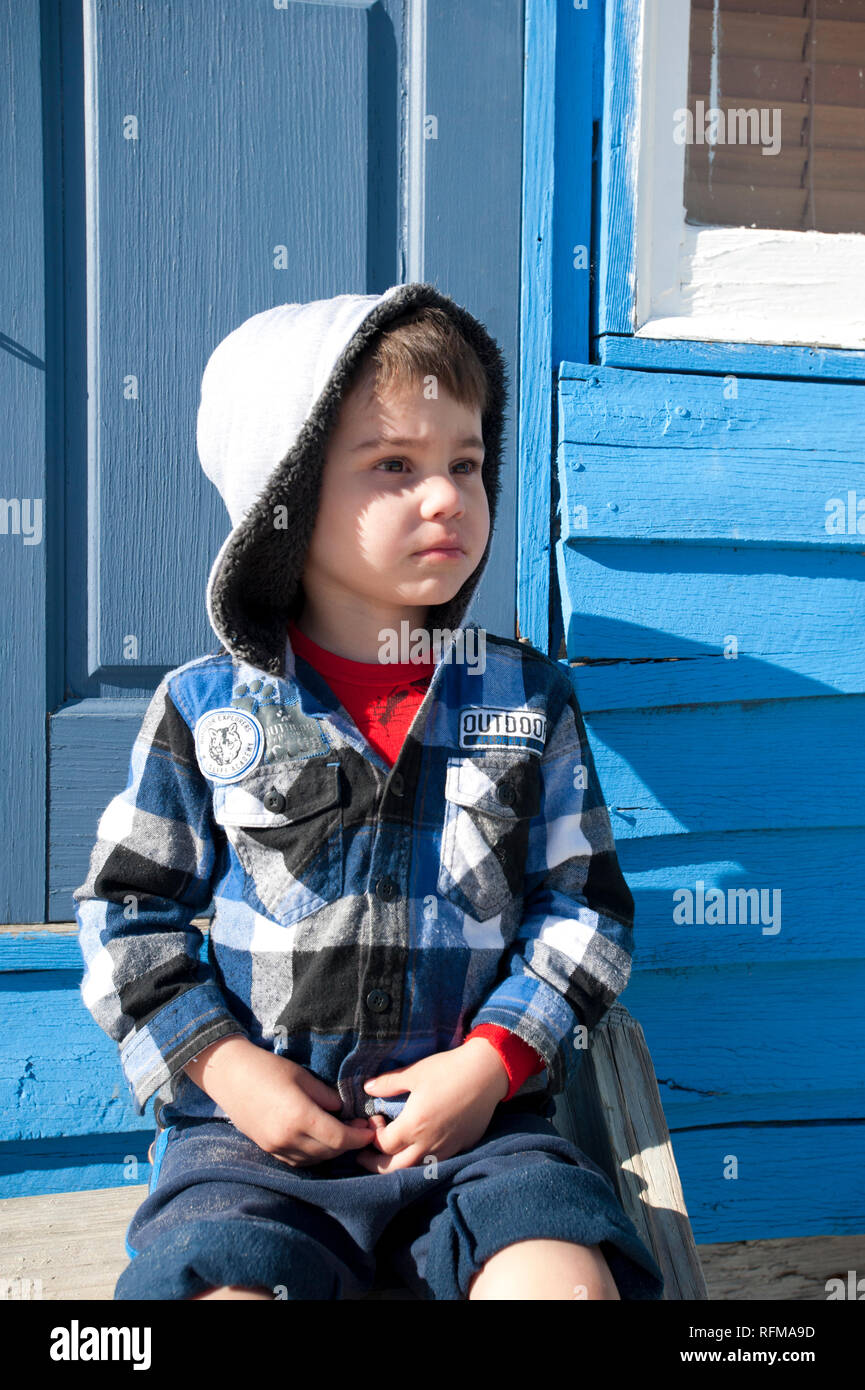 Boy in front of a blue house Stock Photo - Alamy