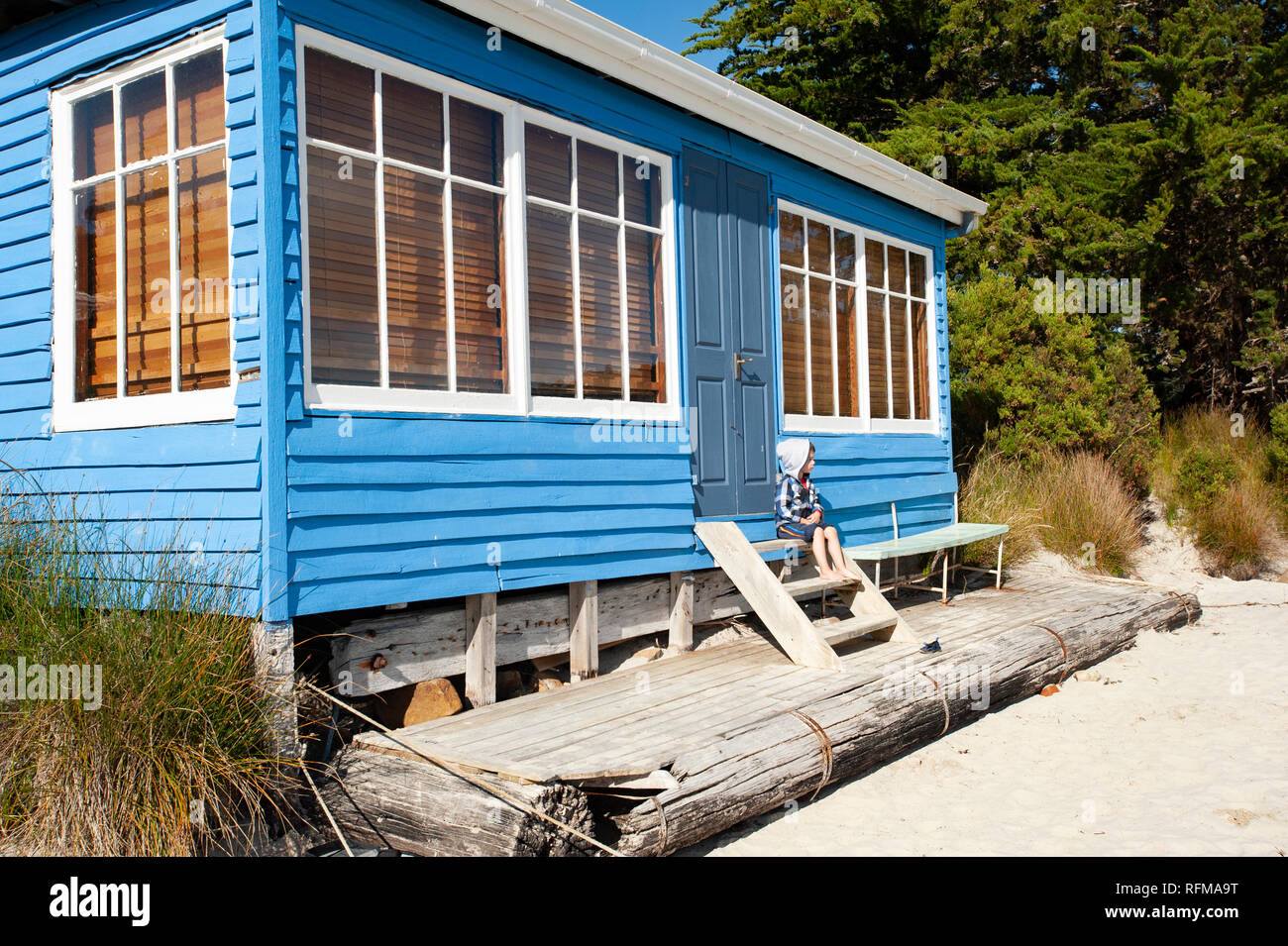 Boy in front of a blue house Stock Photo - Alamy
