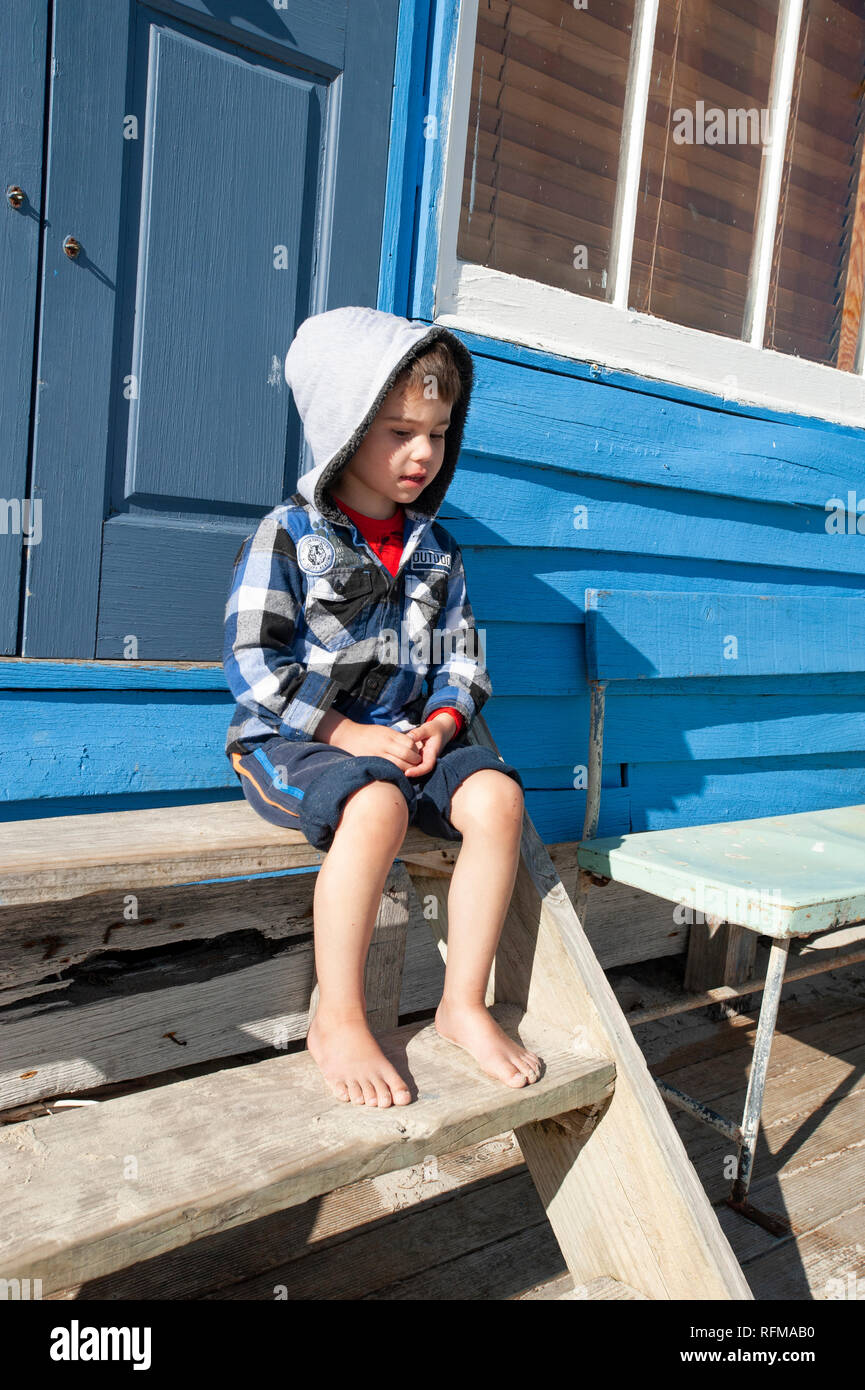 Boy in front of a blue house Stock Photo - Alamy