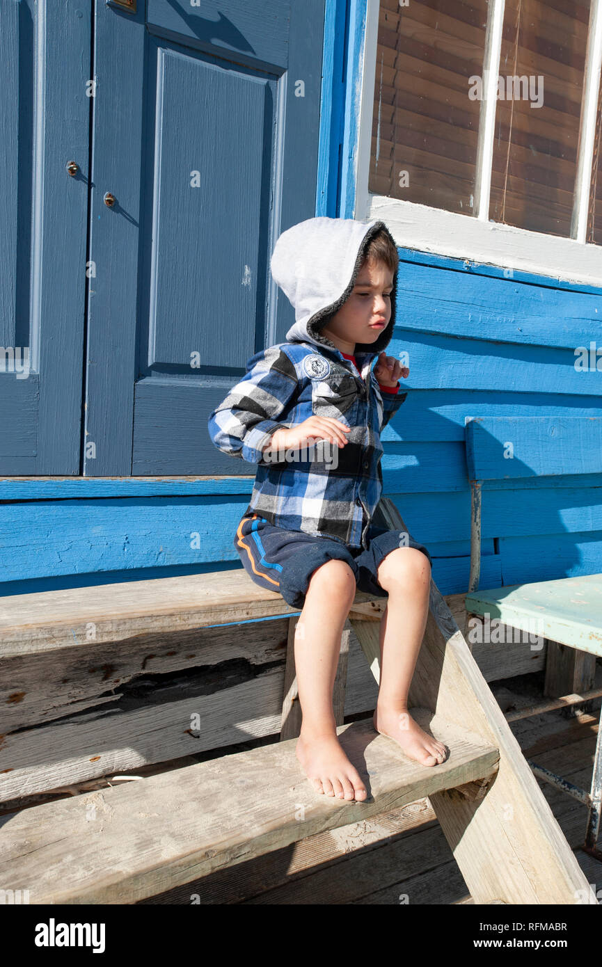 Boy in front of a blue house Stock Photo - Alamy
