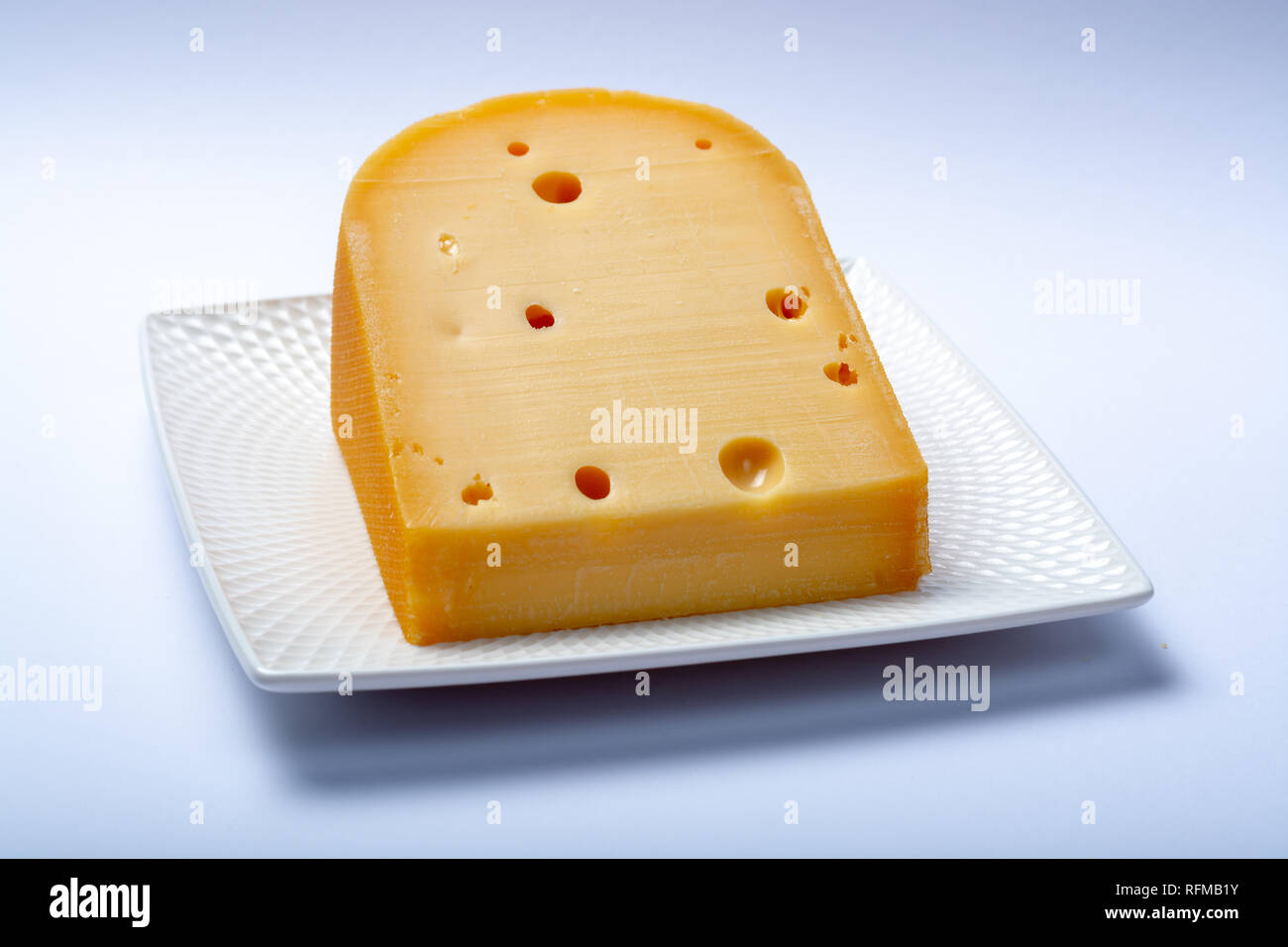 One piece of traditional Dutch old hard cheese made from cow milk close ...