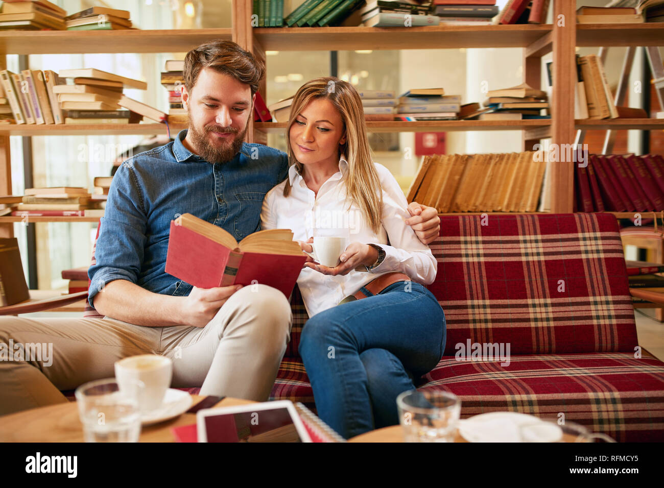 Young couple hugging learn together indoor Stock Photo - Alamy