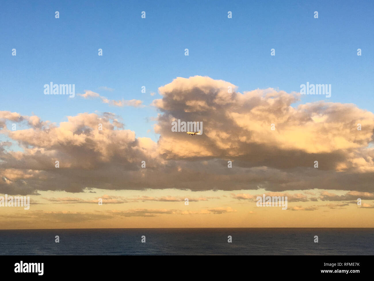 Airplane Flying Against Clouds Over Ocean Stock Photo - Alamy