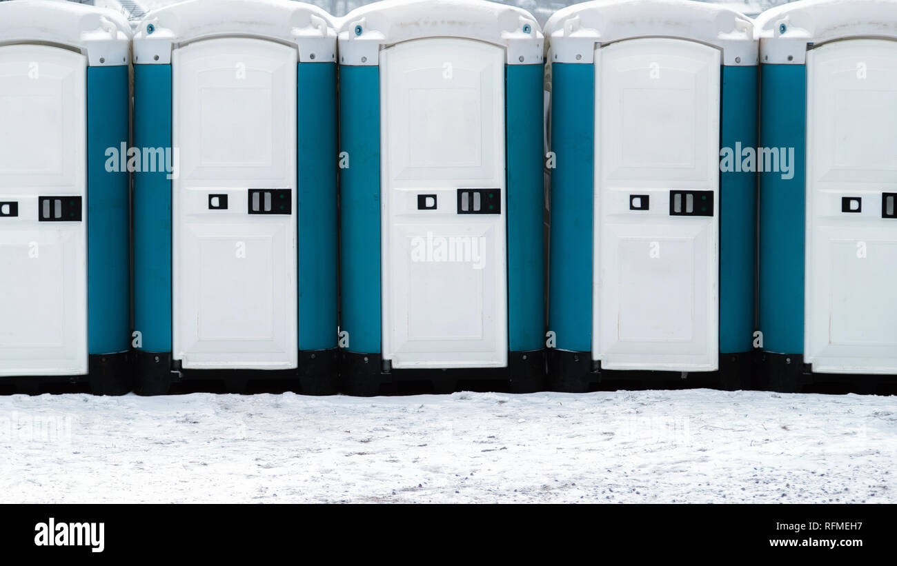 Long row of mobile toilets outside on the snowy ground. Bio toilets ...