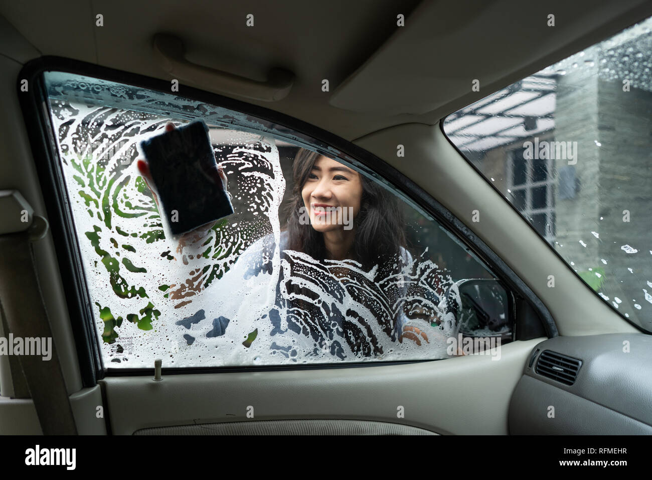 woman wash her car window with soap Stock Photo - Alamy