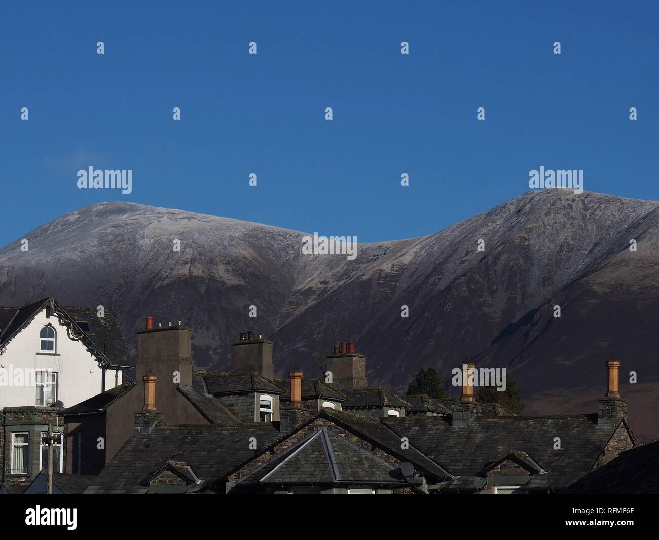 The roofs of Portinscale with the mountain of Skiddaw behind ...