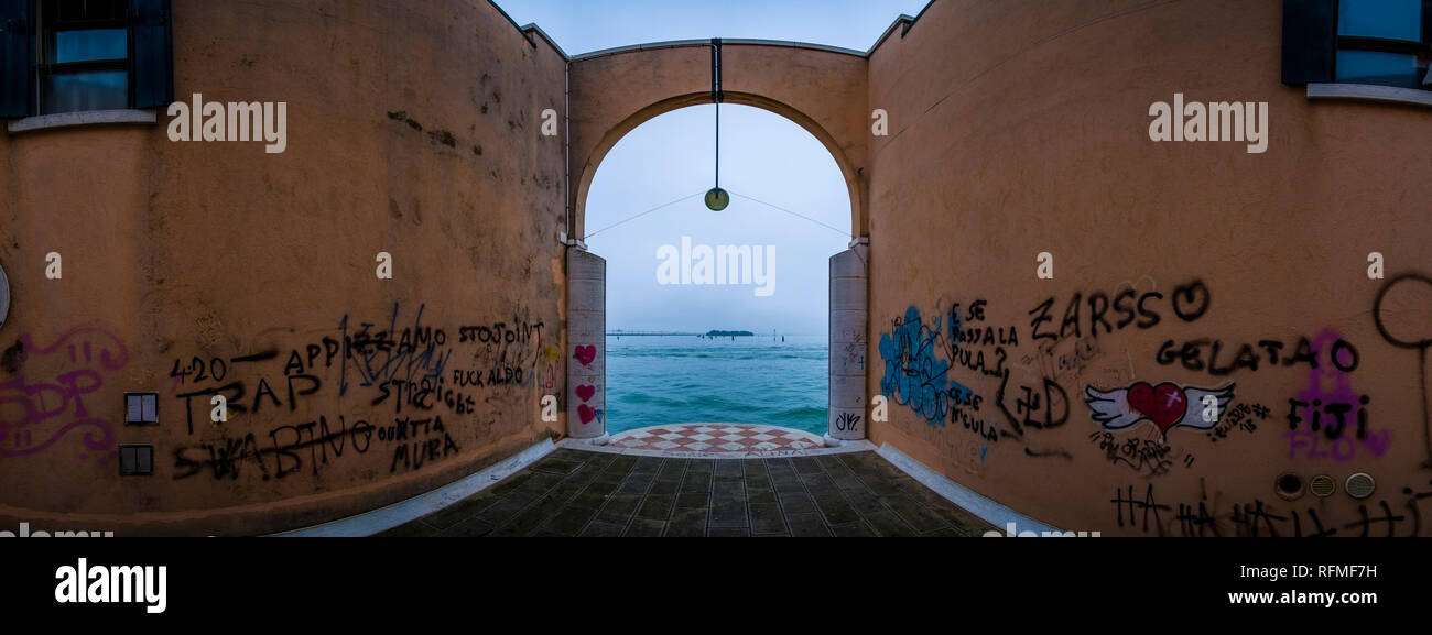 Panoramic view of a gate, sprayed with colorful graffity, leading out ...