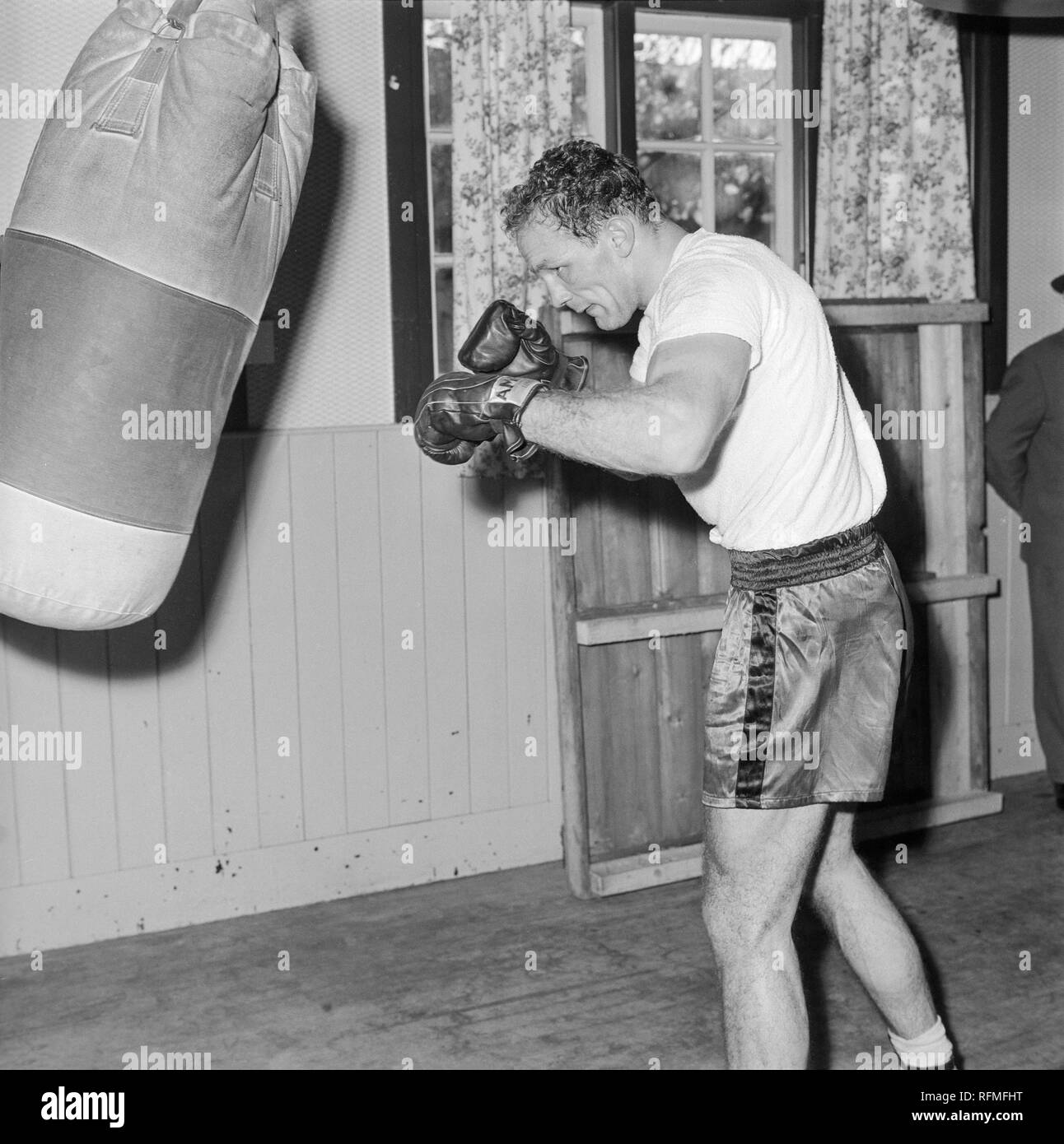 English heavyweight boxer Henry Cooper trying in a gym in England ...