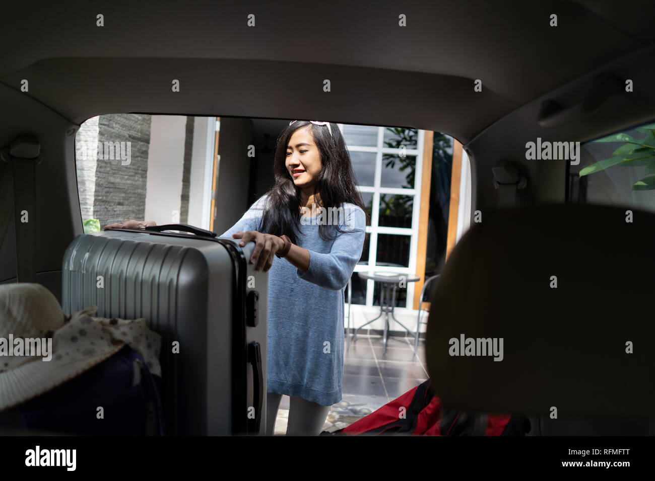 Woman putting suitcase car hi-res stock photography and images - Alamy