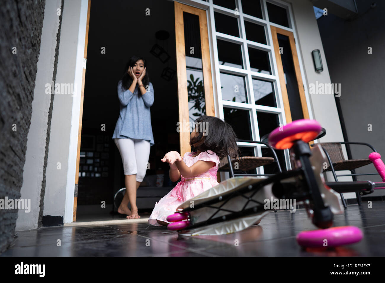 shocked mom looking at her daughter fell from scooter Stock Photo - Alamy