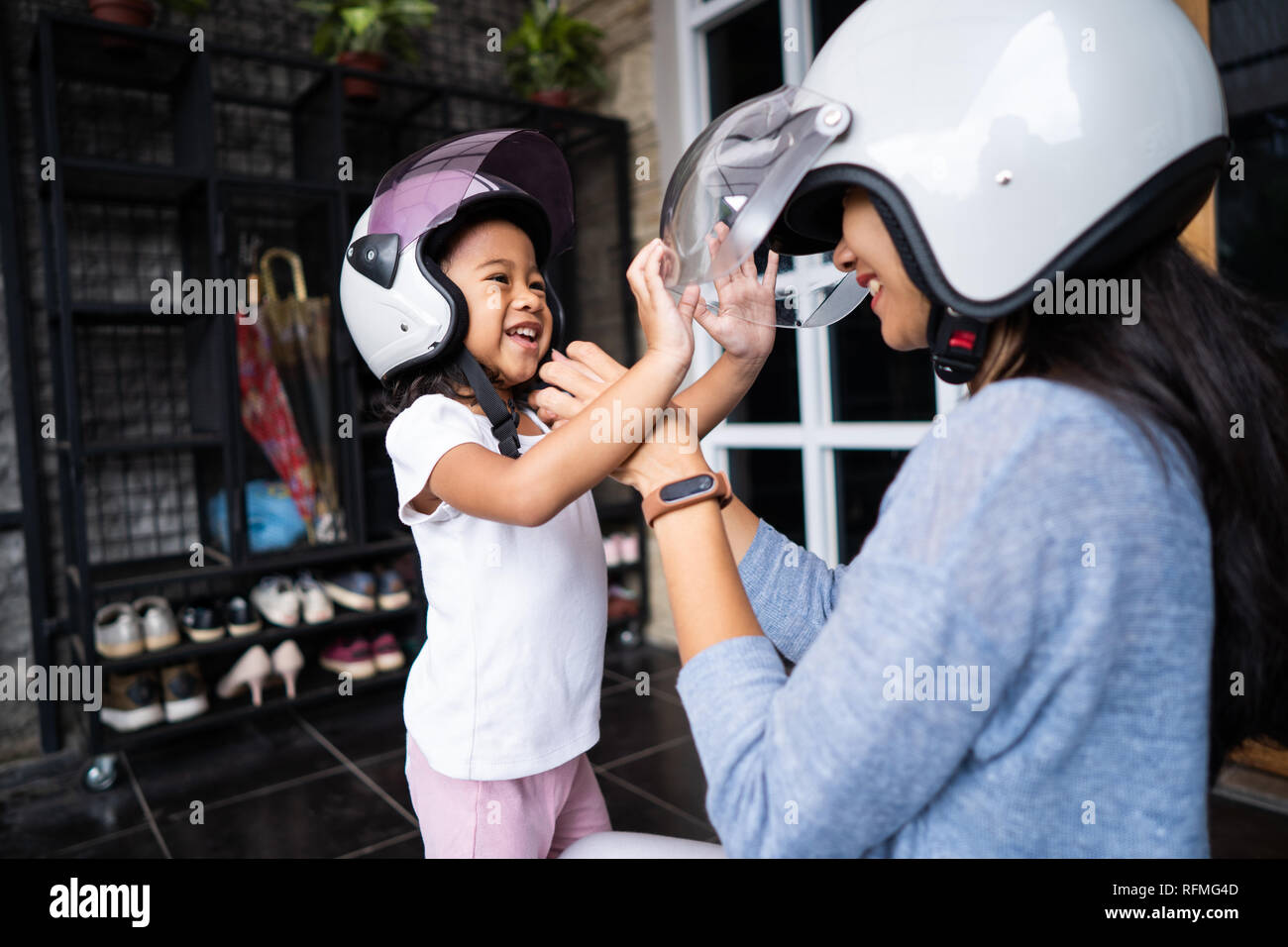 mom helped her daughter to put on helmet Stock Photo - Alamy