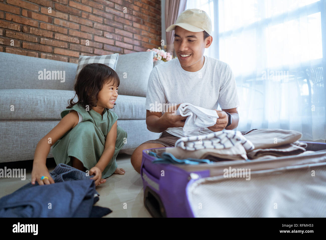 daughter helping her dad to put clothes in to the suitcase Stock Photo ...