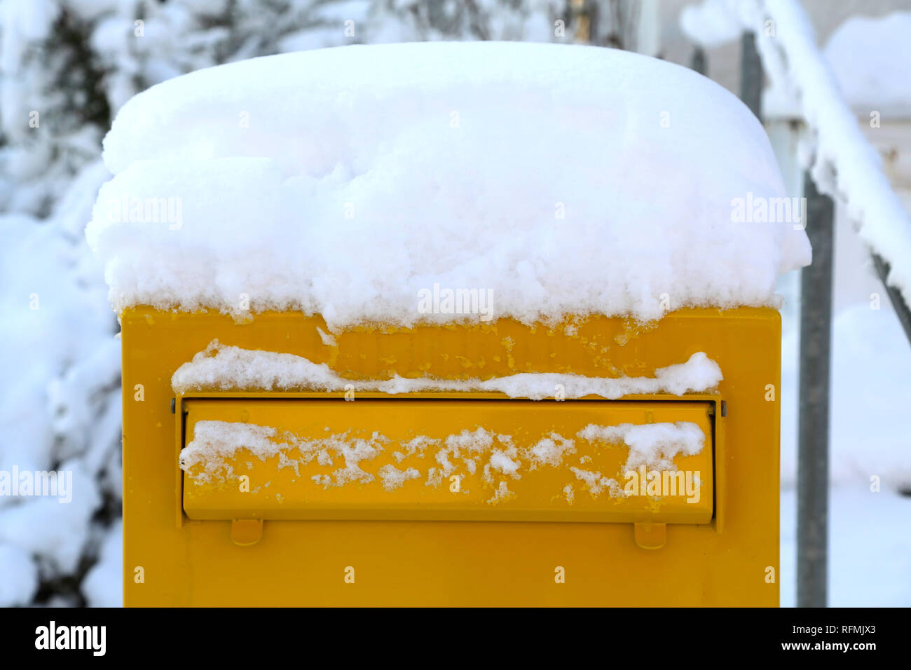Yellow post box covered with a thick layer of snow Stock Photo - Alamy