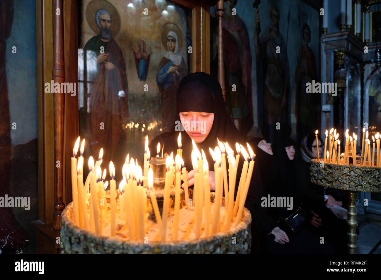An eastern Orthodox nun lights candles inside the Greek Orthodox chapel ...
