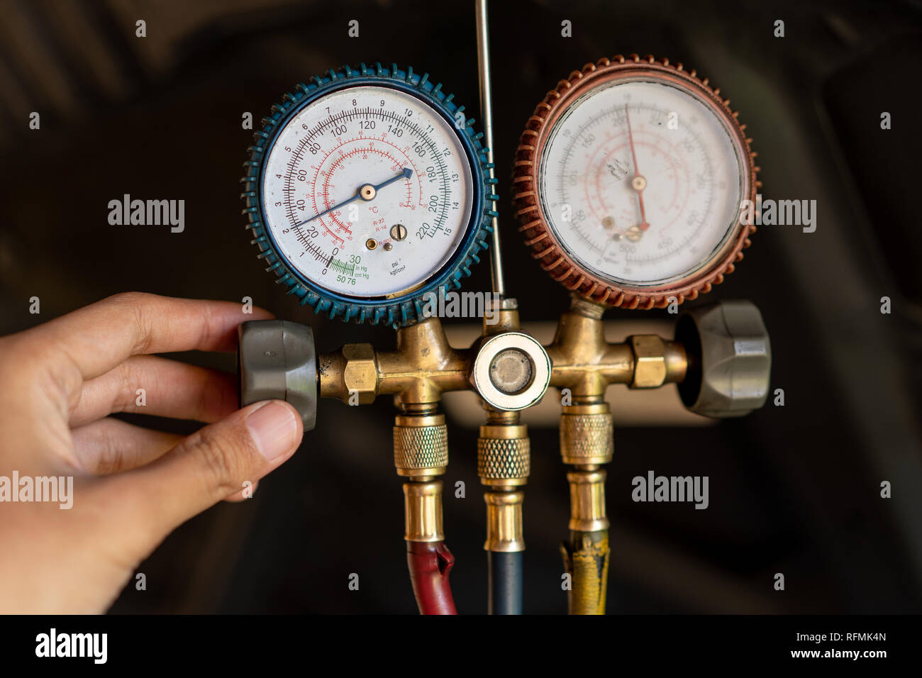 portrait of a mechanic hand uses a pressure gauge to know a function of ...