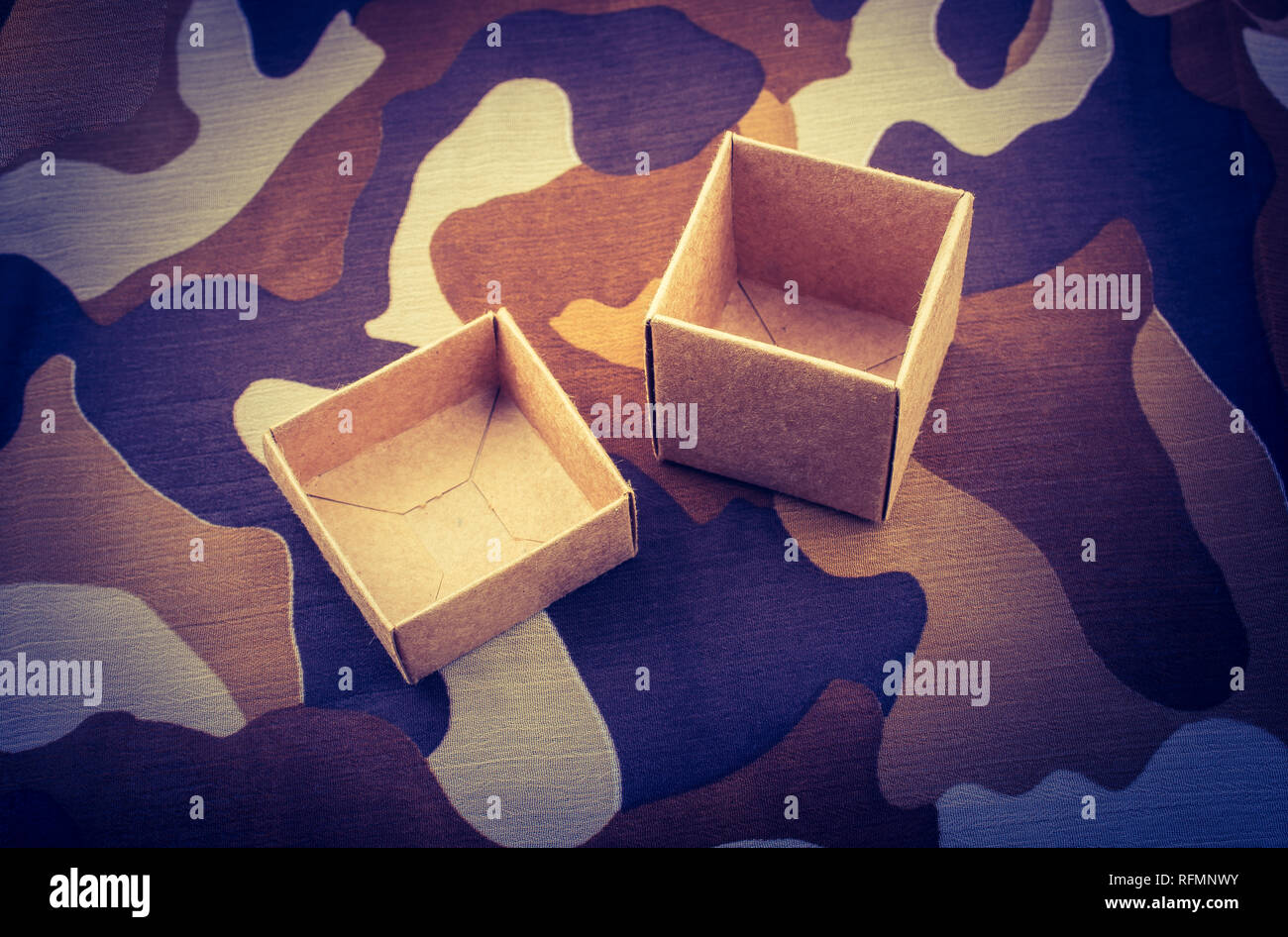 Two open cardboard boxes on a camouflage background Stock Photo - Alamy