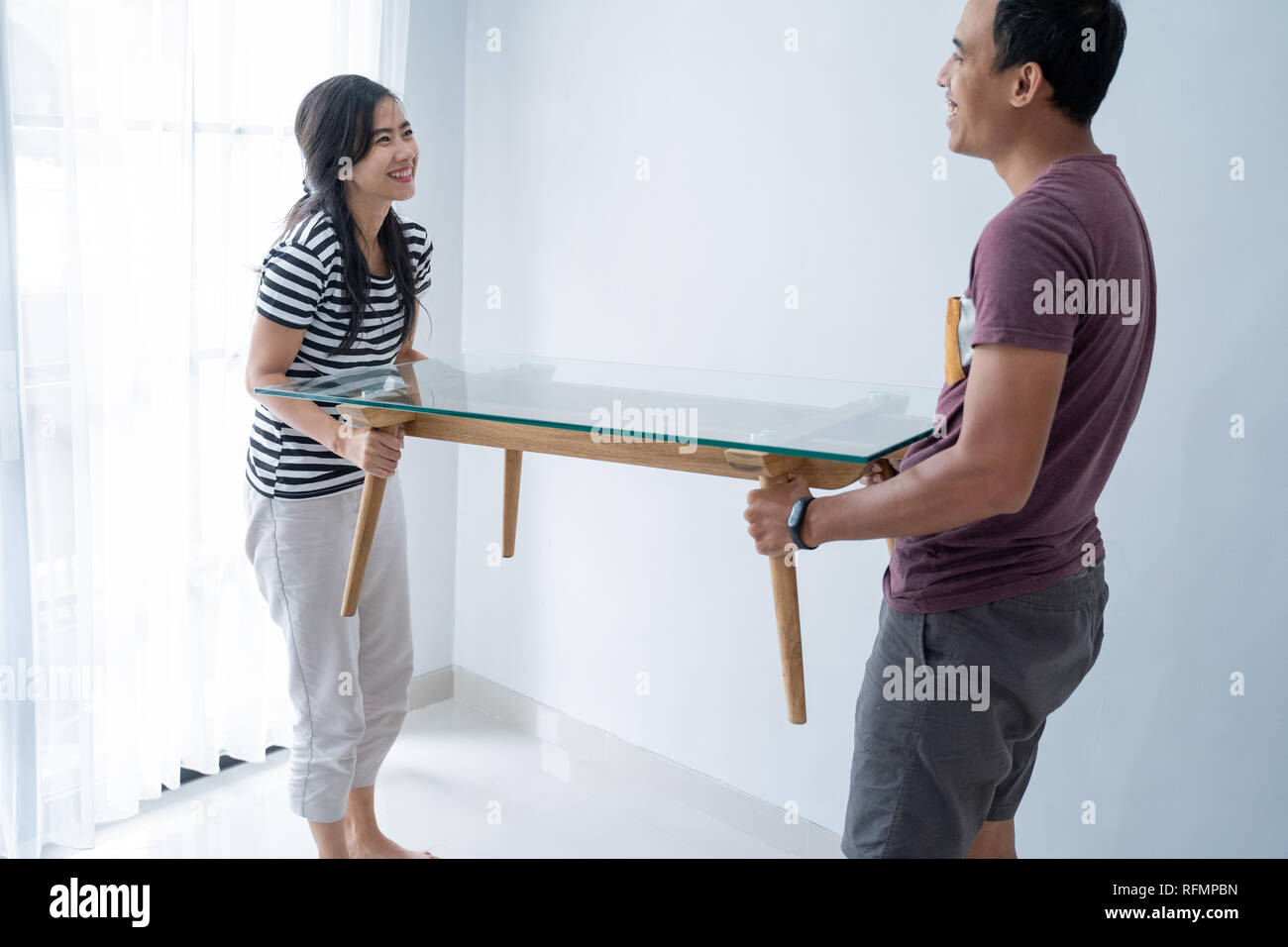 New couples together lift the table to fill the furniture Stock Photo ...