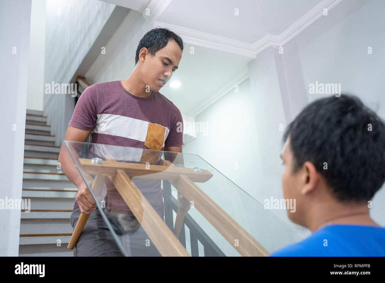 young asian man move a table upstair Stock Photo - Alamy