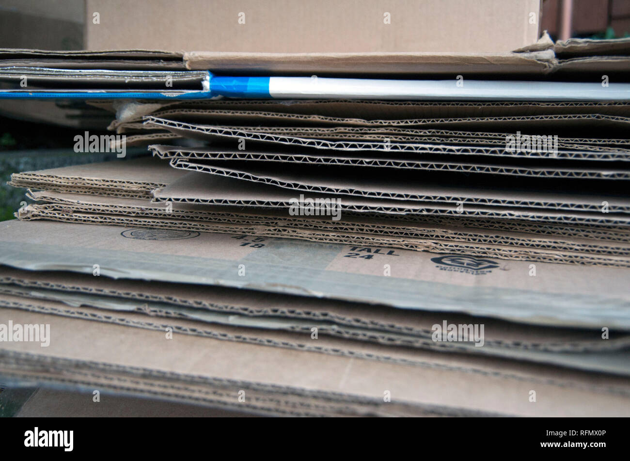 A stack of old cardboard boxes sits on top of a recycling bin in San ...