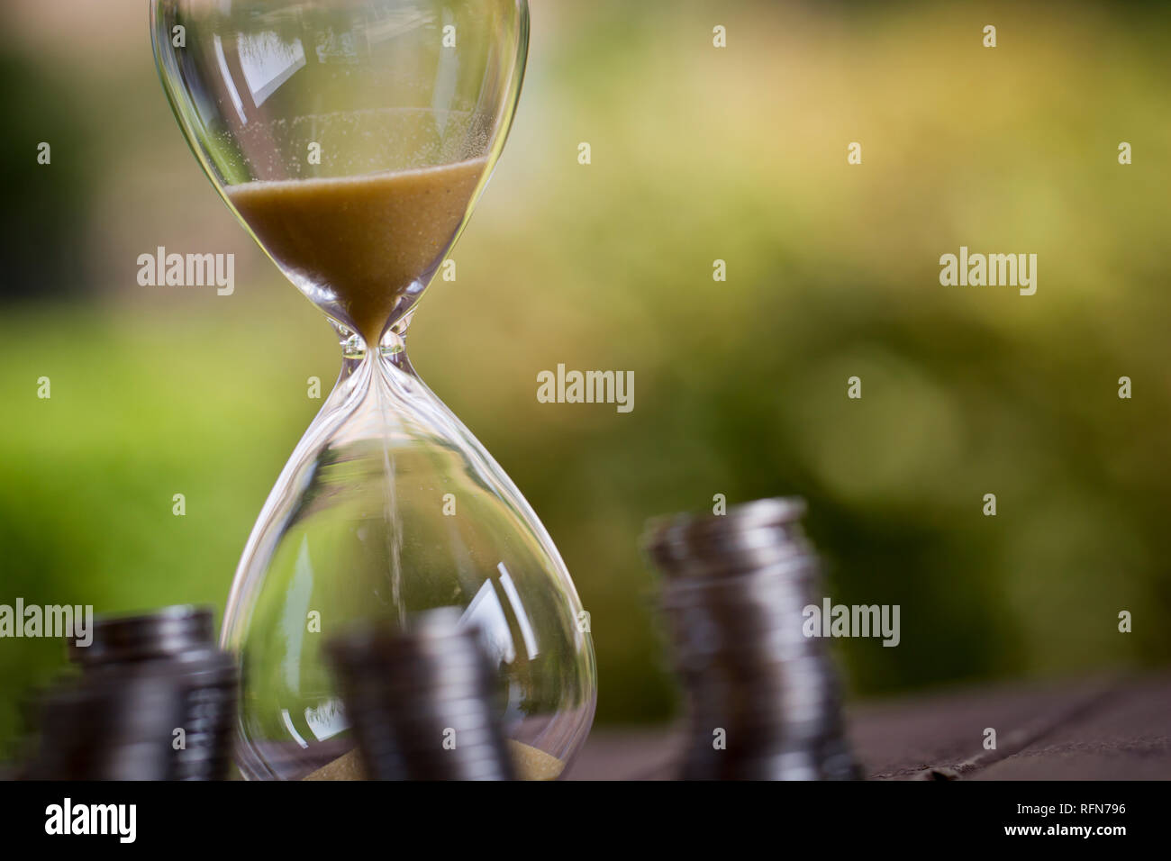 Hourglass and money, time and wealth accumulation Stock Photo - Alamy