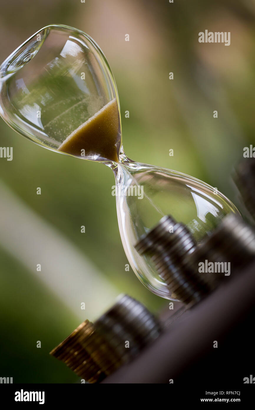 Hourglass and money, time and wealth accumulation Stock Photo - Alamy