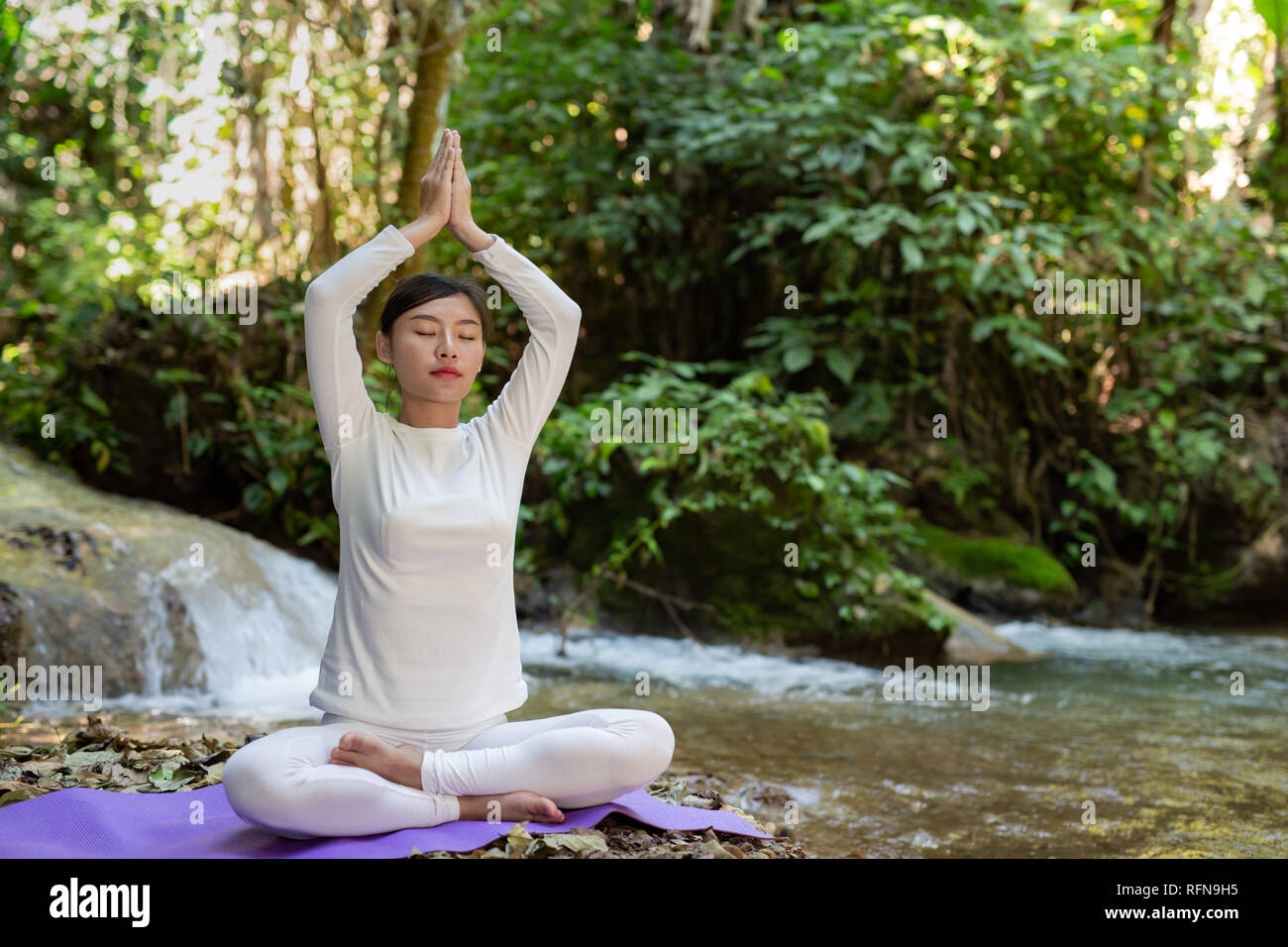 Beautiful girls are playing yoga at the park. Among the natural ...