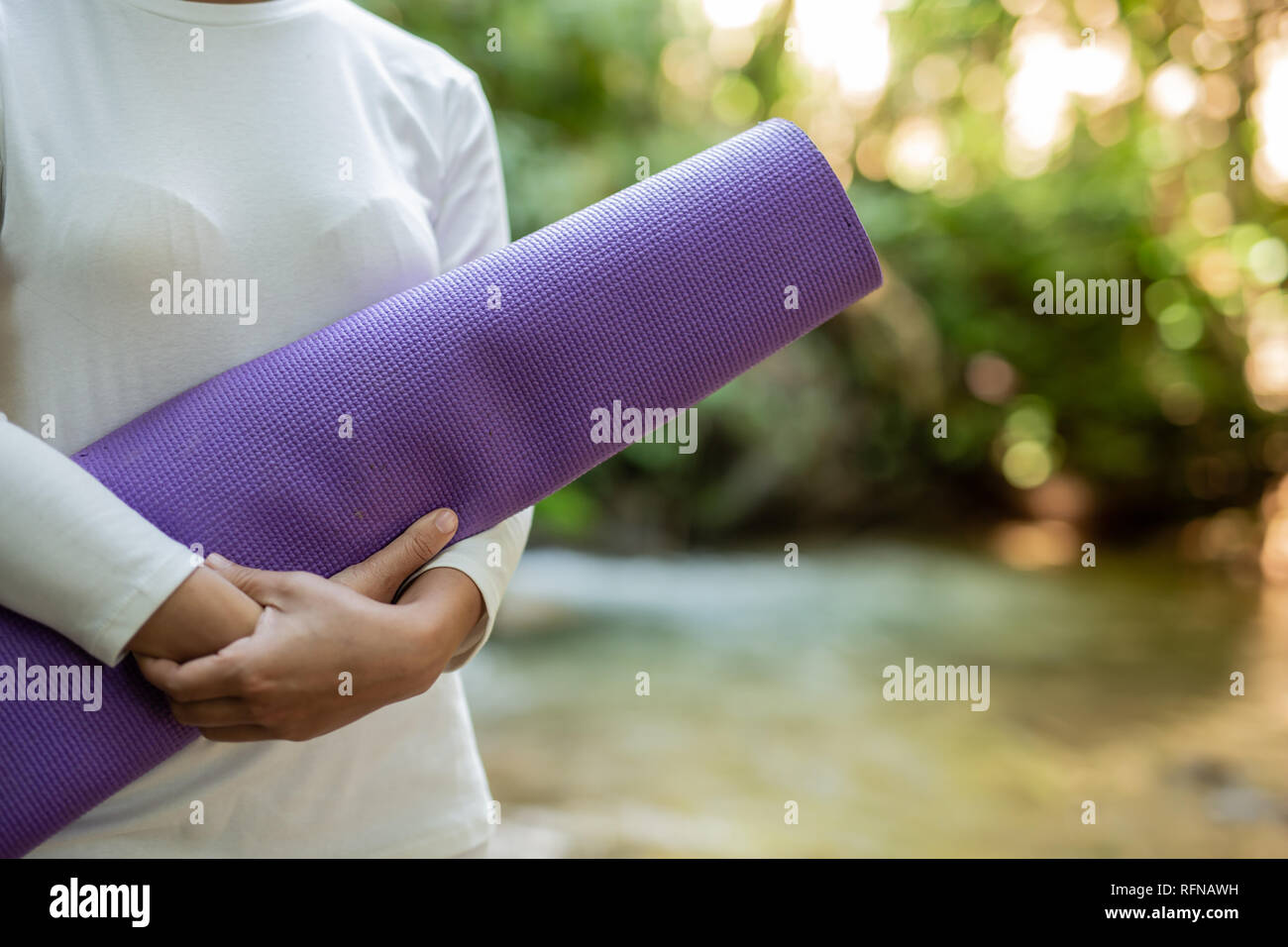 Women wearing a white yoga dress are rolling yoga at the waterfall ...