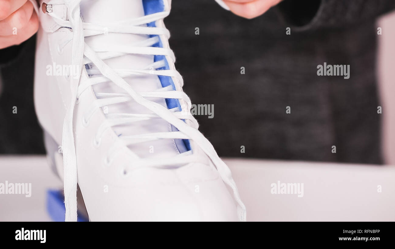 Lacing new white figure skates with white laces Stock Photo - Alamy