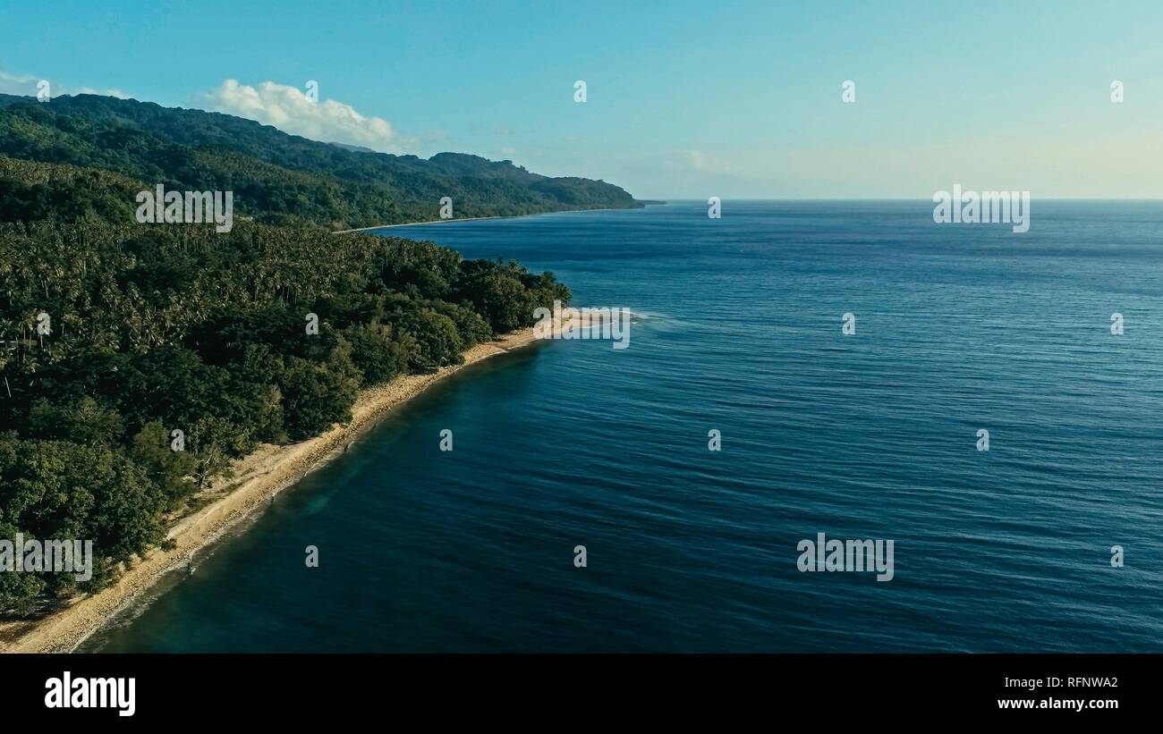 aerial drone image of a remote south pacific island with sandy beach ...
