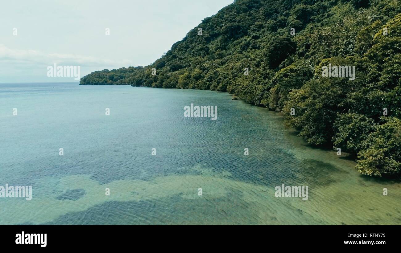 aerial drone image of a remote south pacific island with sandy beach ...