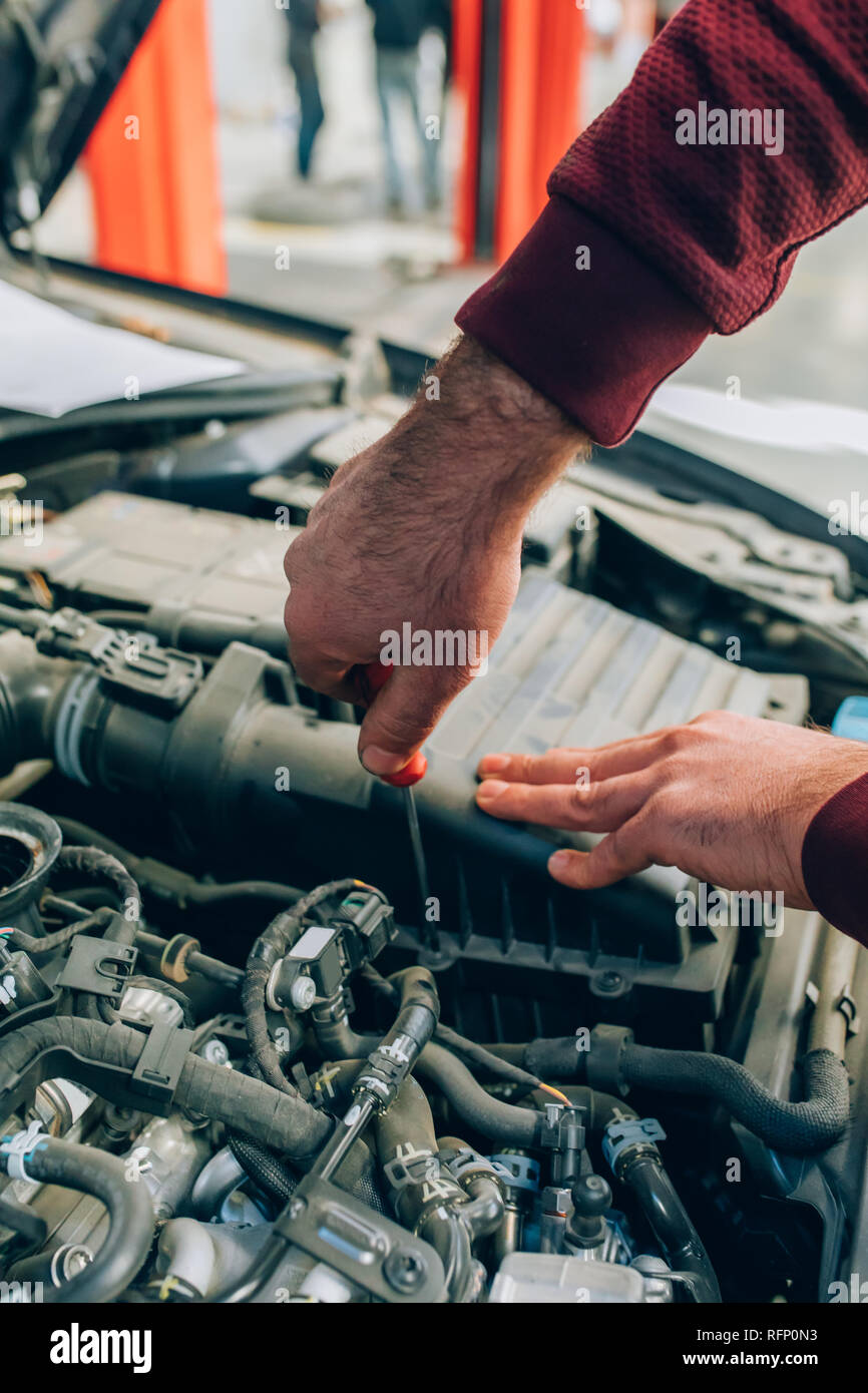Auto mechanic working in garage during the maintenance of engine ...