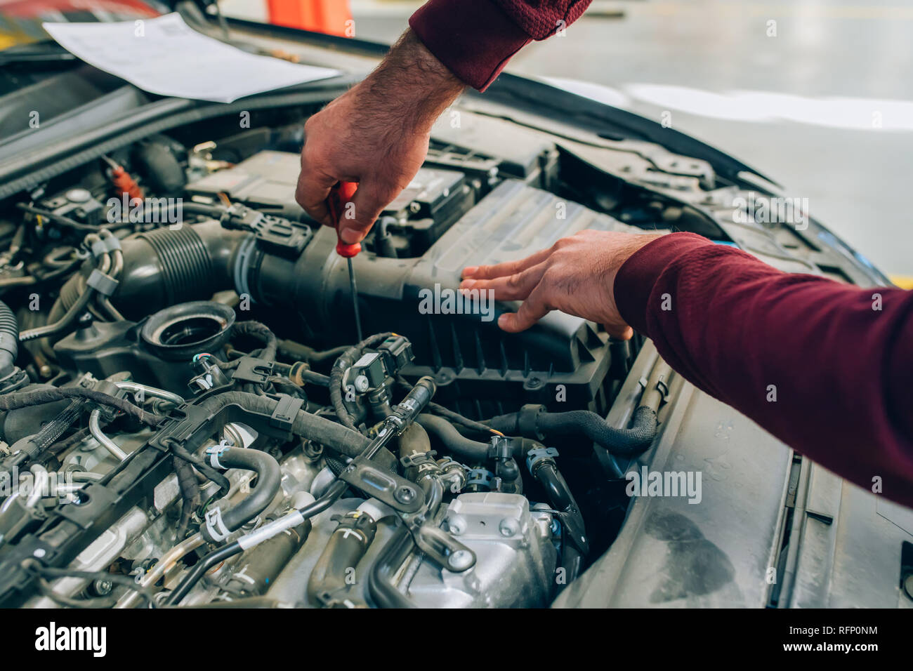 Auto mechanic working in garage during the maintenance of engine ...
