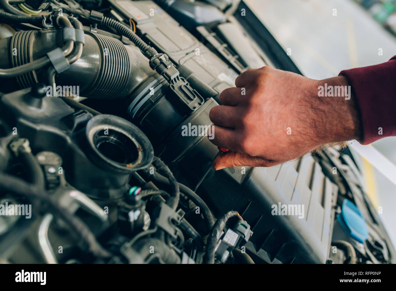 Auto mechanic working in garage during the maintenance of engine ...