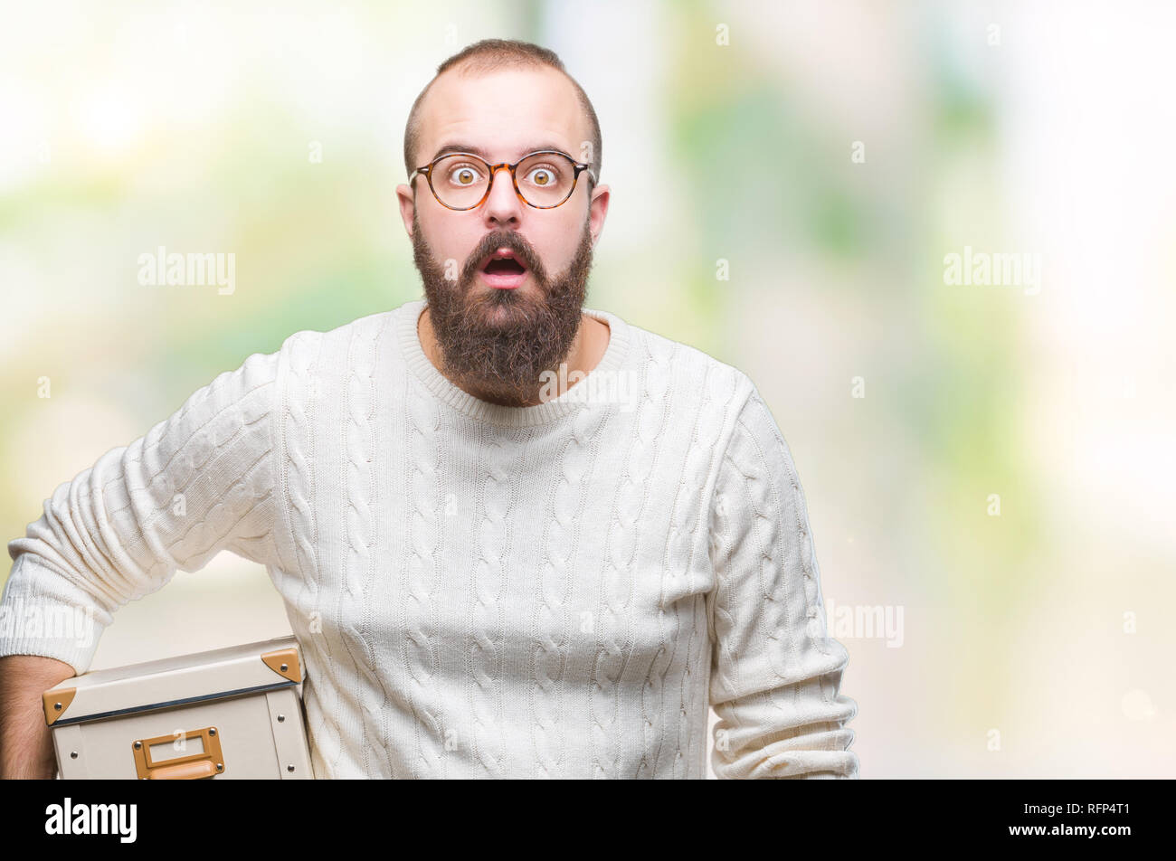 Young hipster man wearing glasses, moving holding moving box over ...