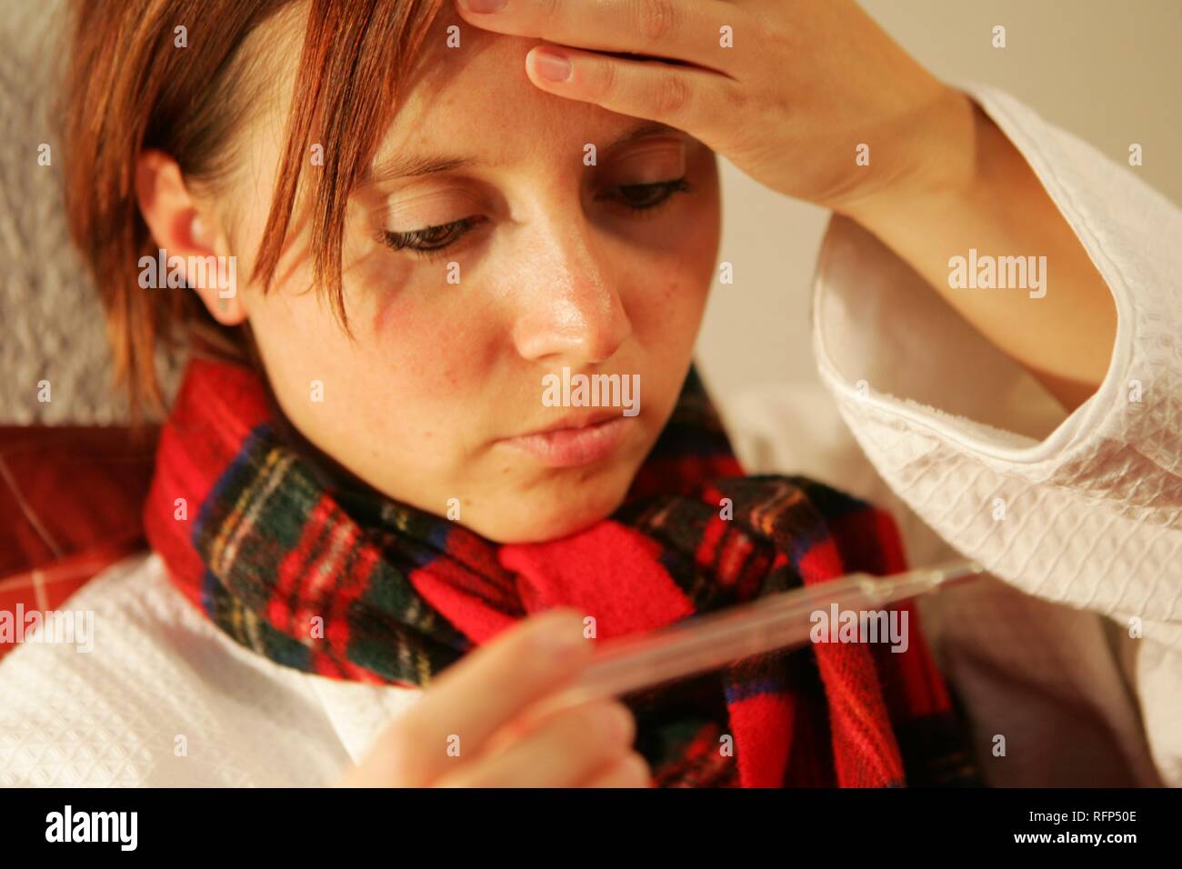 Woman measures her blood heat with a clinical thermometer, common cold ...