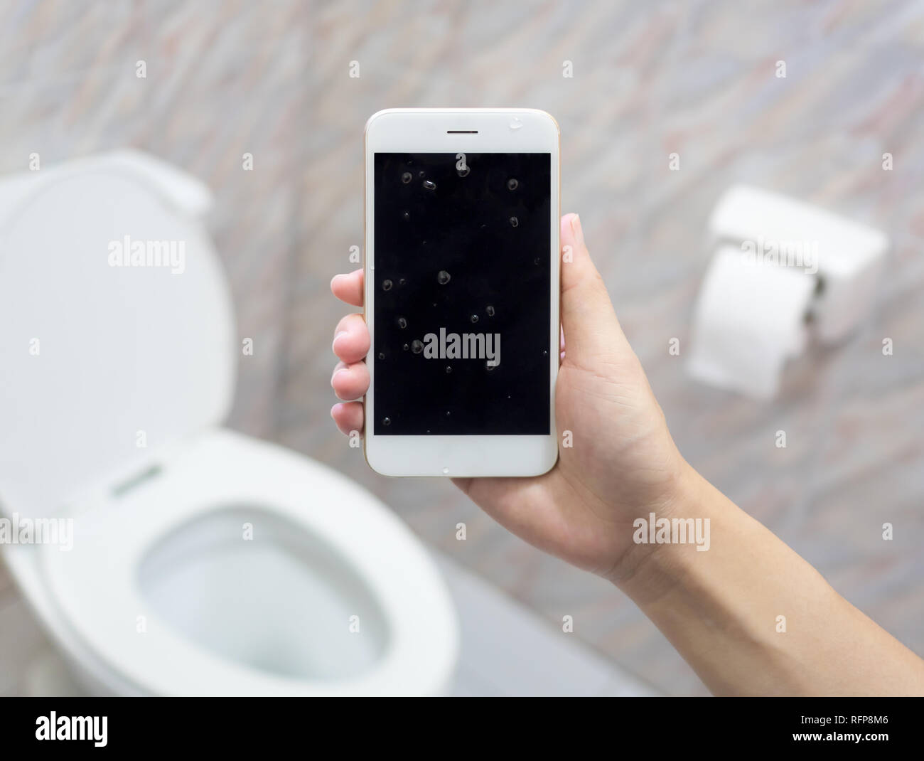 Human hand holding wet smart phone in water closet. Water damage ...
