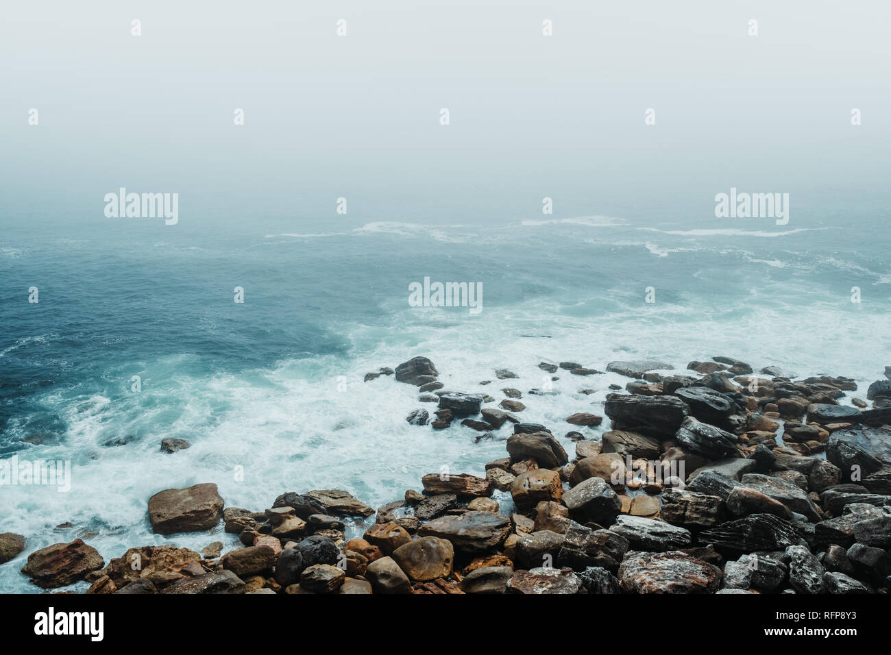 A moody scene of Ocean Mist on a Rocky Shore Stock Photo - Alamy