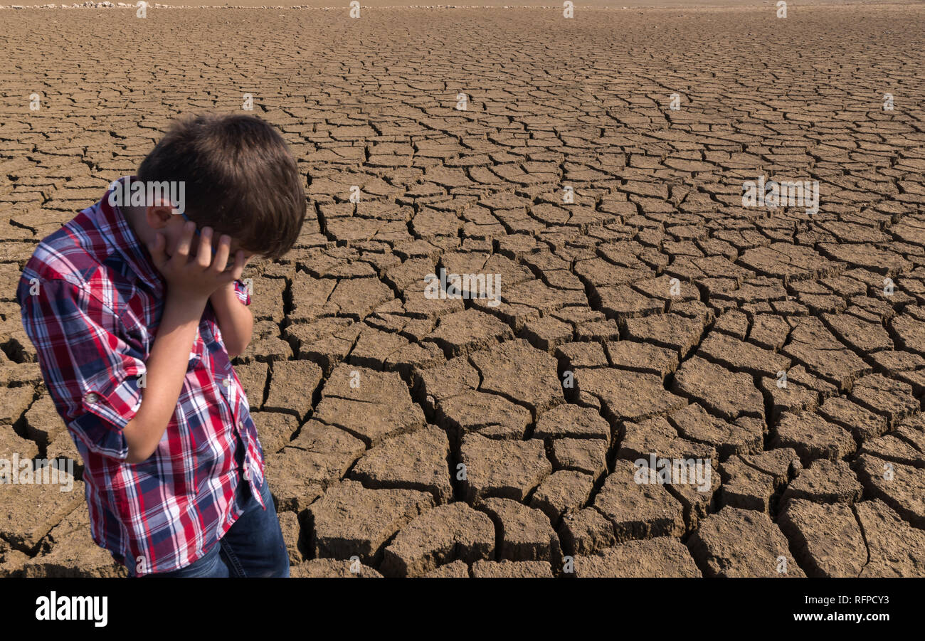 Dry cracked earth background, next to you, sad boy Stock Photo - Alamy
