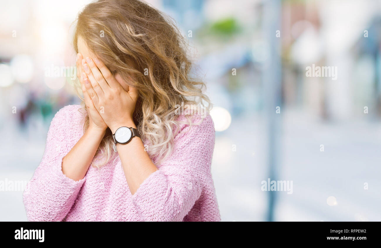 Beautiful young blonde woman over isolated background with sad ...